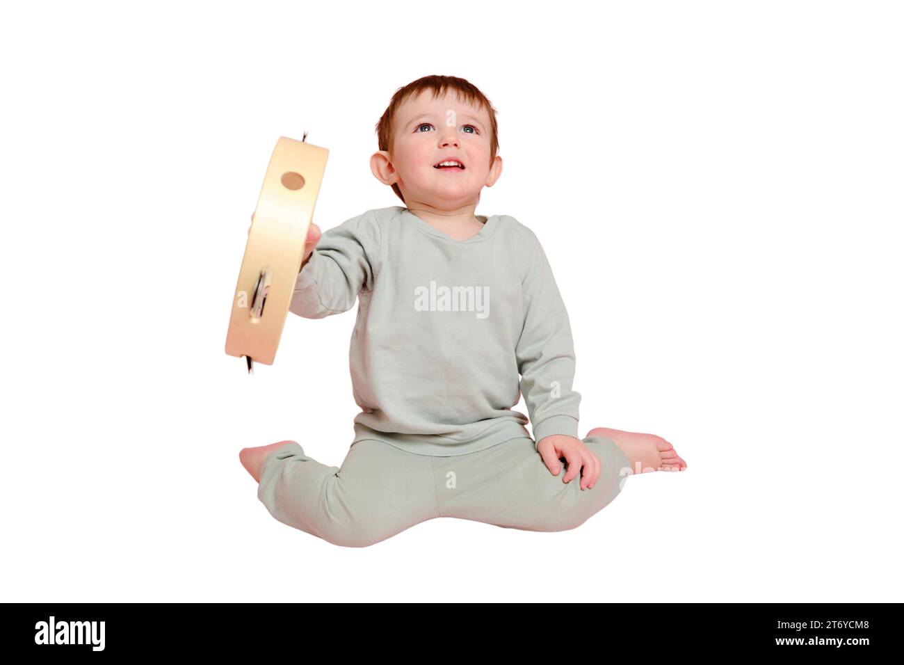 Happy toddler baby with a musical instrument tambourine on a studio ...