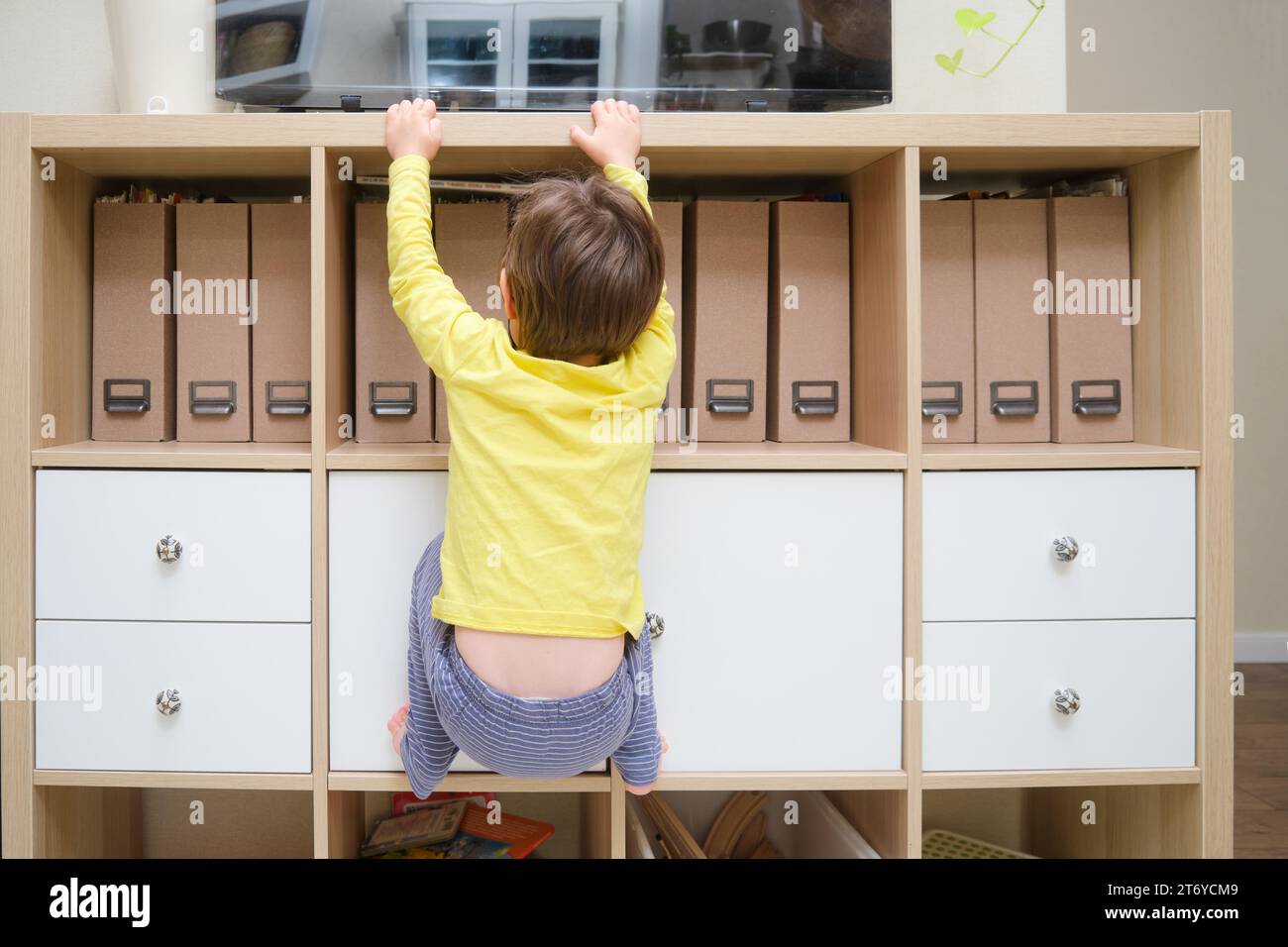 The baby is reaching for the television, posing a dangerous hazard. Kid ...