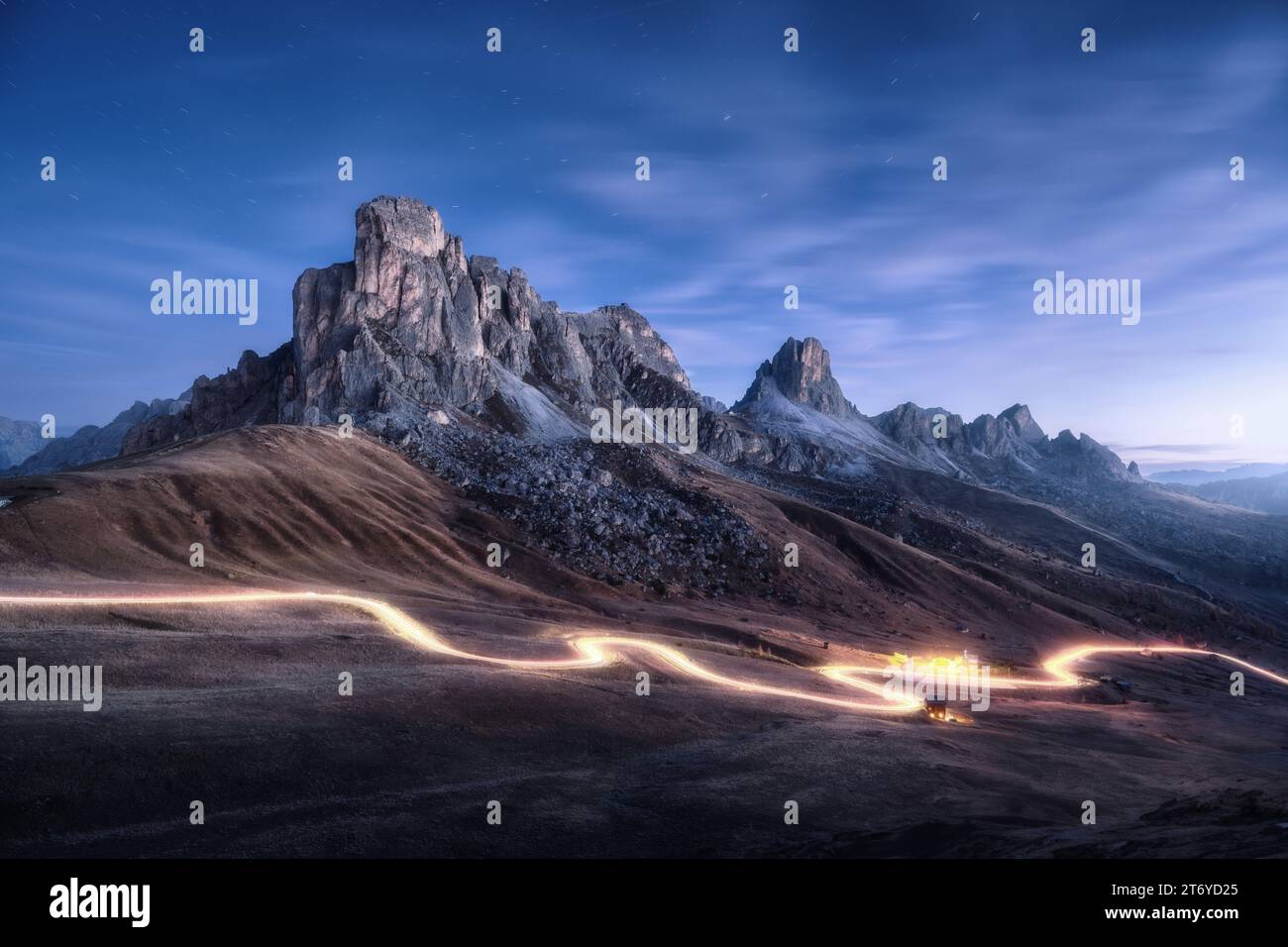 Car light trails on mountain road and high rocks at night Stock Photo ...