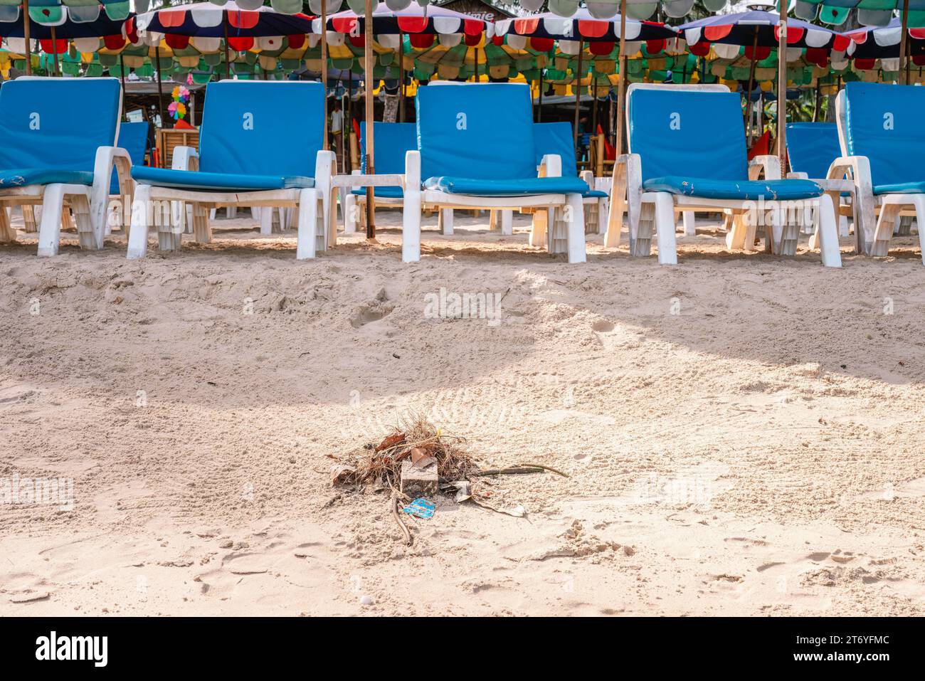 Beach workers swept garbage by broom on sandy beach in front of plastic ...