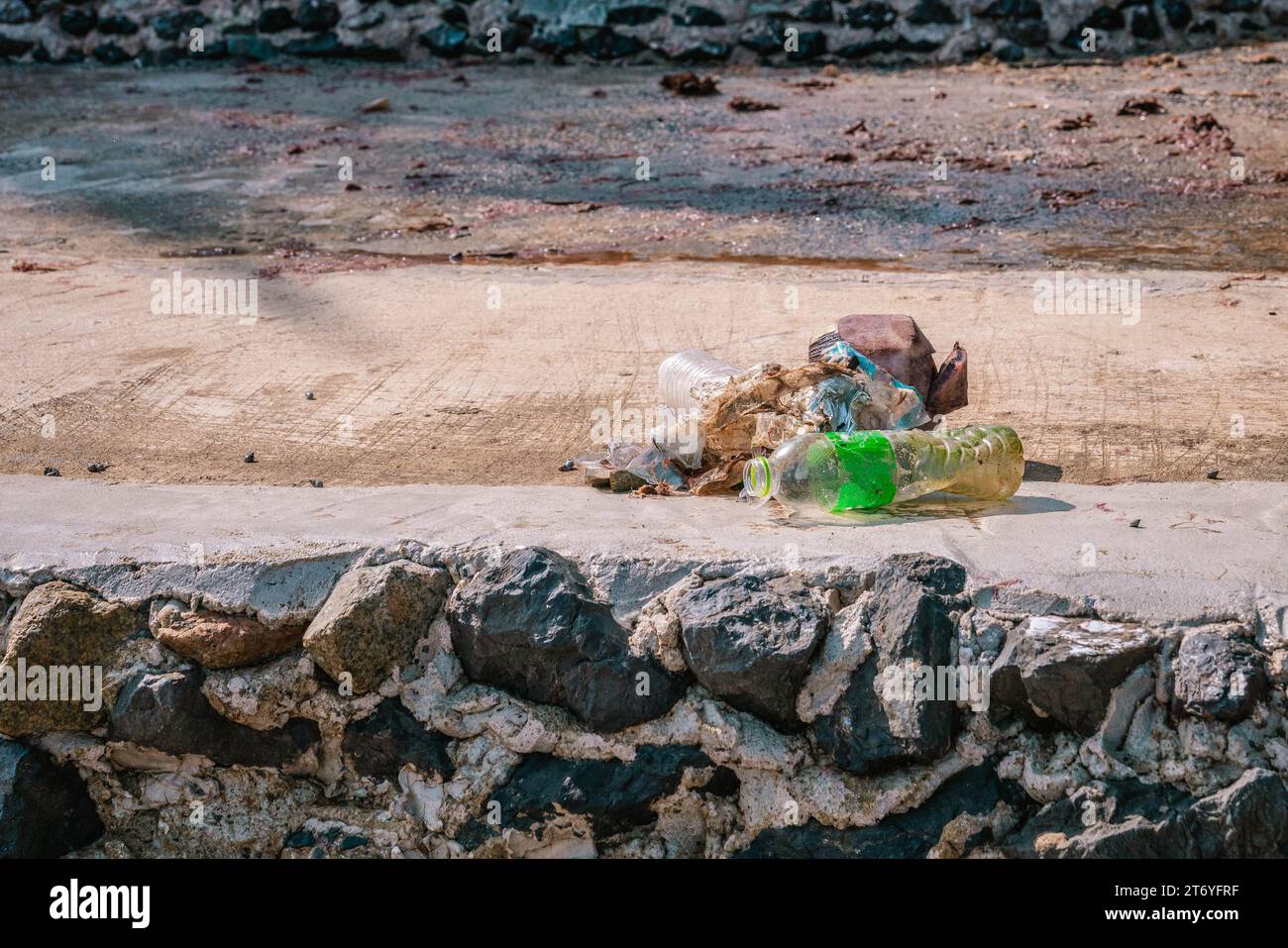 Plastic garbage collected from seashore left at concrete sidewalk ...