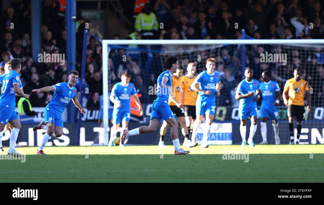 Joel Randall (PU), centre, wheels away after scoring the fifth Posh ...