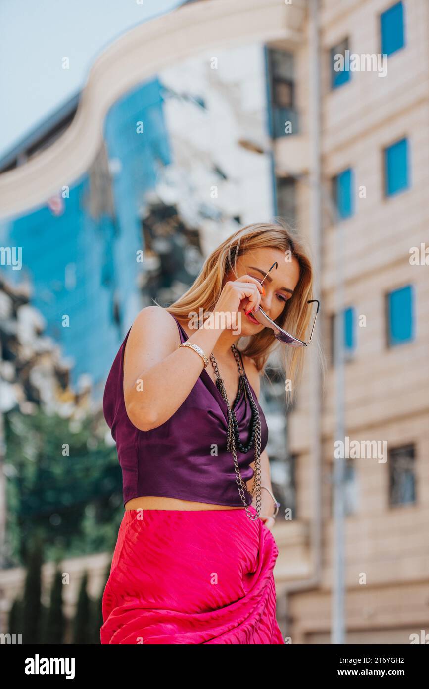 An elegant, attractive lady confidently poses in trendy street fashion ...