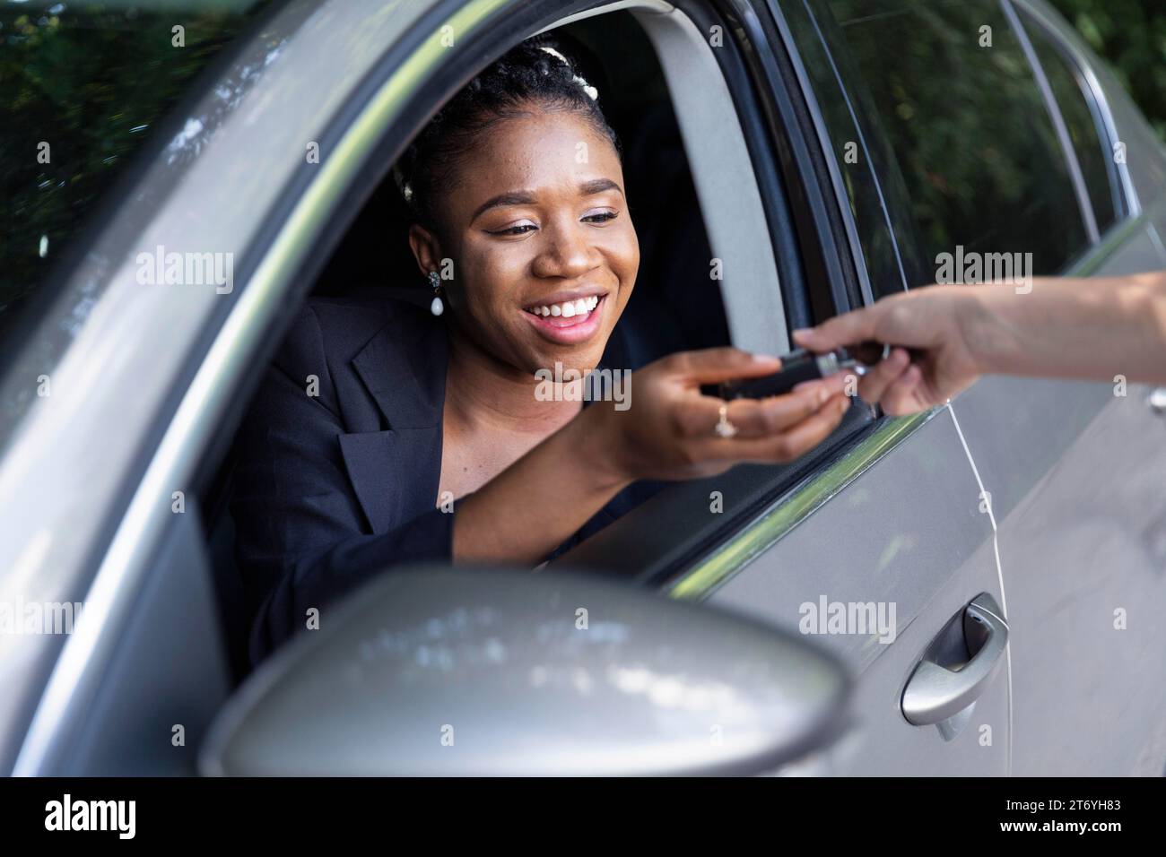 Smiley woman being handed keys her new car Stock Photo - Alamy
