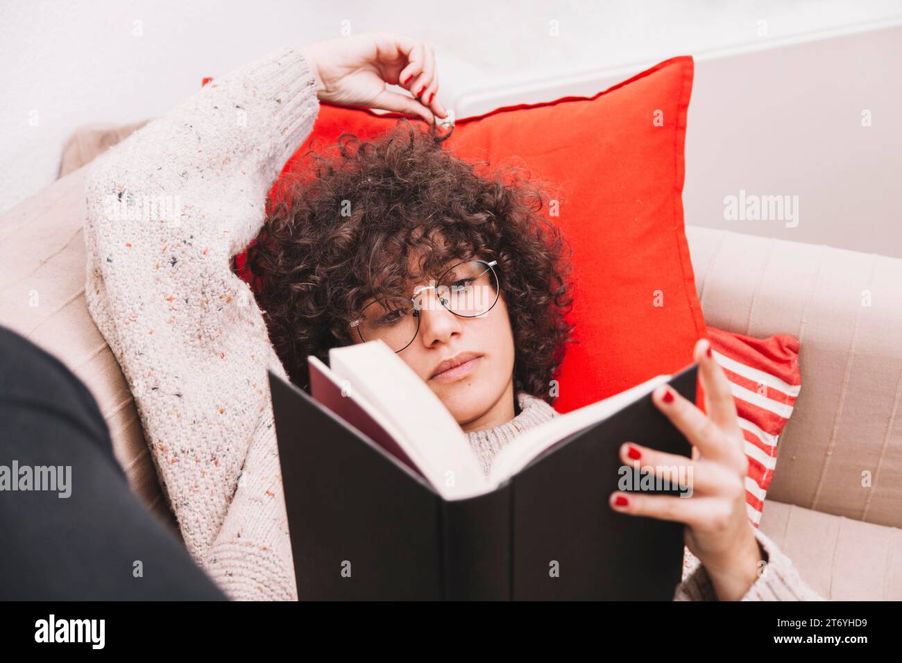Teenager reading sofa Stock Photo - Alamy