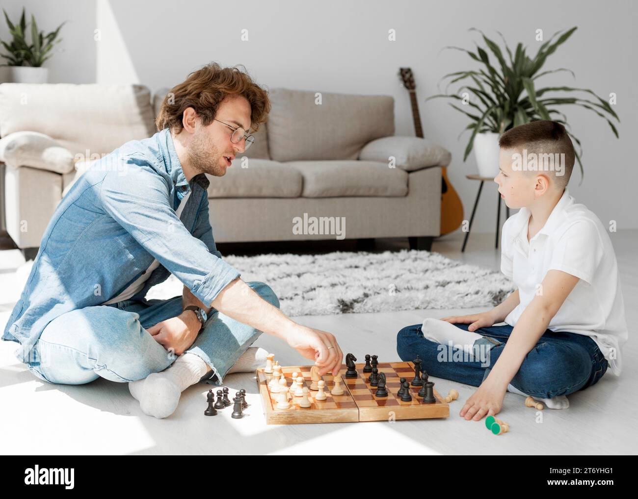Tutor learning boy how play chess Stock Photo - Alamy