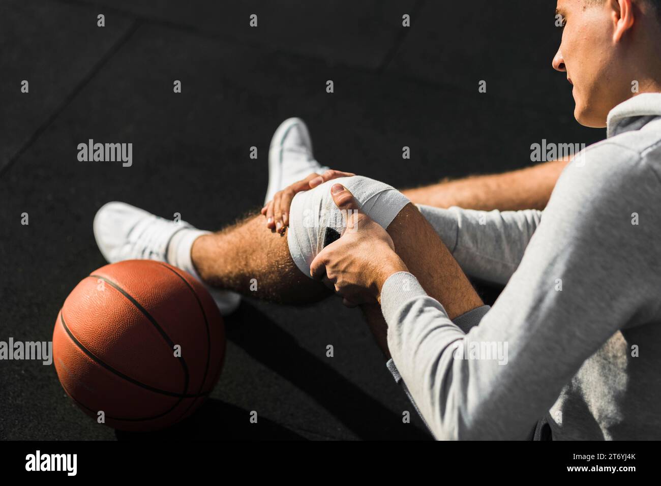 Basketball player applying bandage knee Stock Photo - Alamy