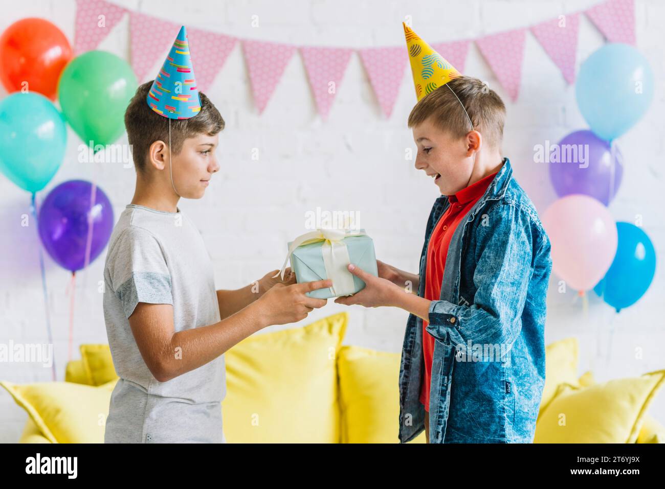 Boy giving birthday gift his friend Stock Photo - Alamy