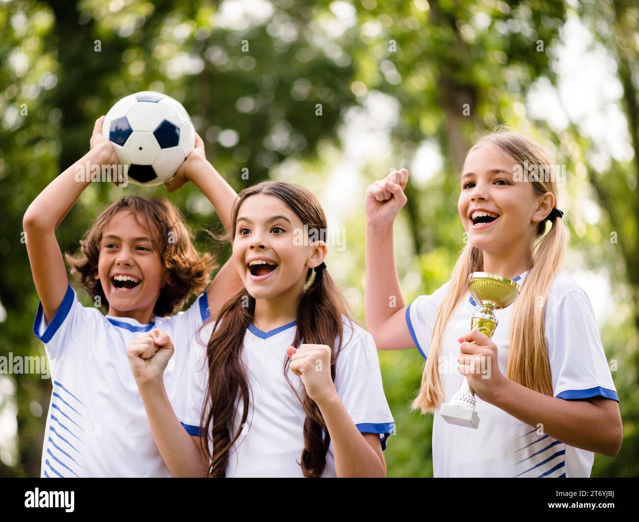 Children getting trophy after winning football match Stock Photo - Alamy