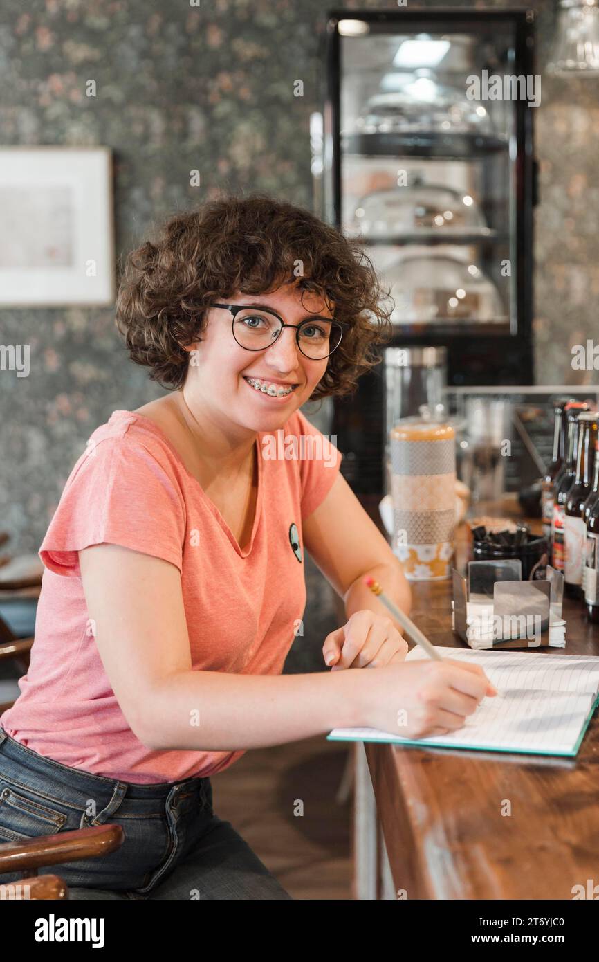 Cheerful teenager doing homework cafe Stock Photo - Alamy