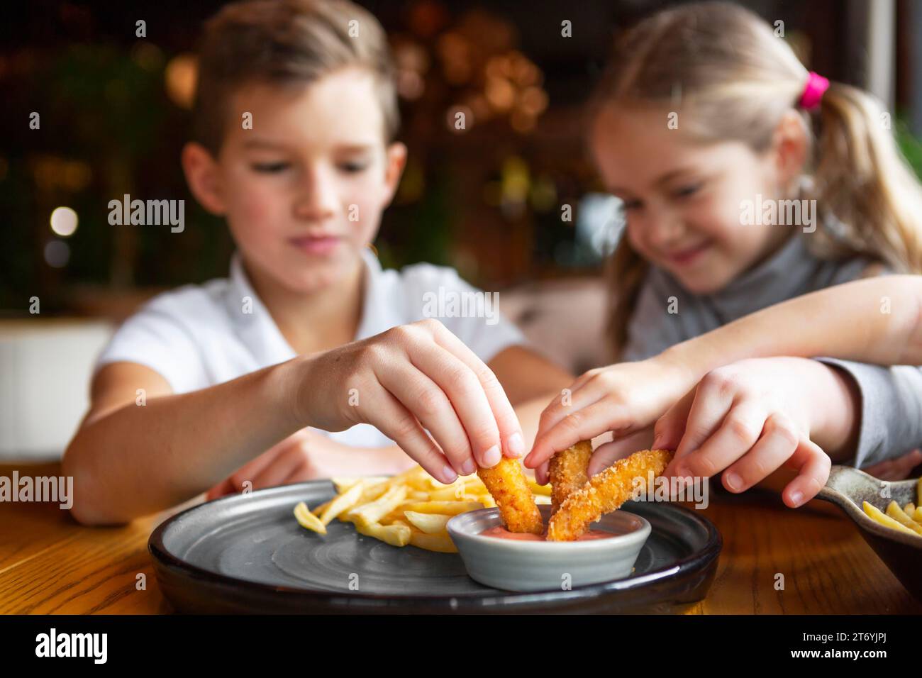 Close up smiley kids eating fast food Stock Photo - Alamy