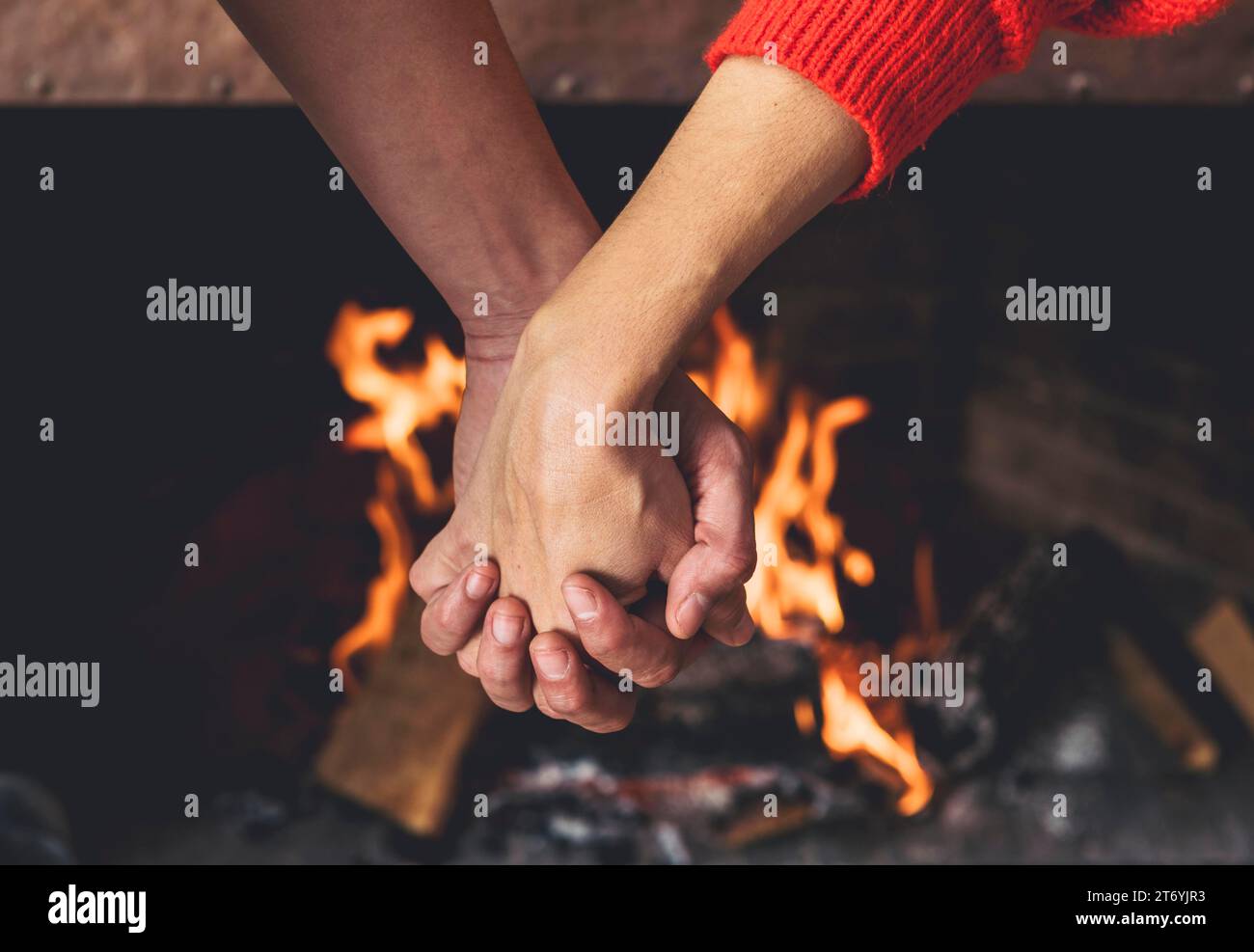 Couple holding hands near fireplace Stock Photo - Alamy