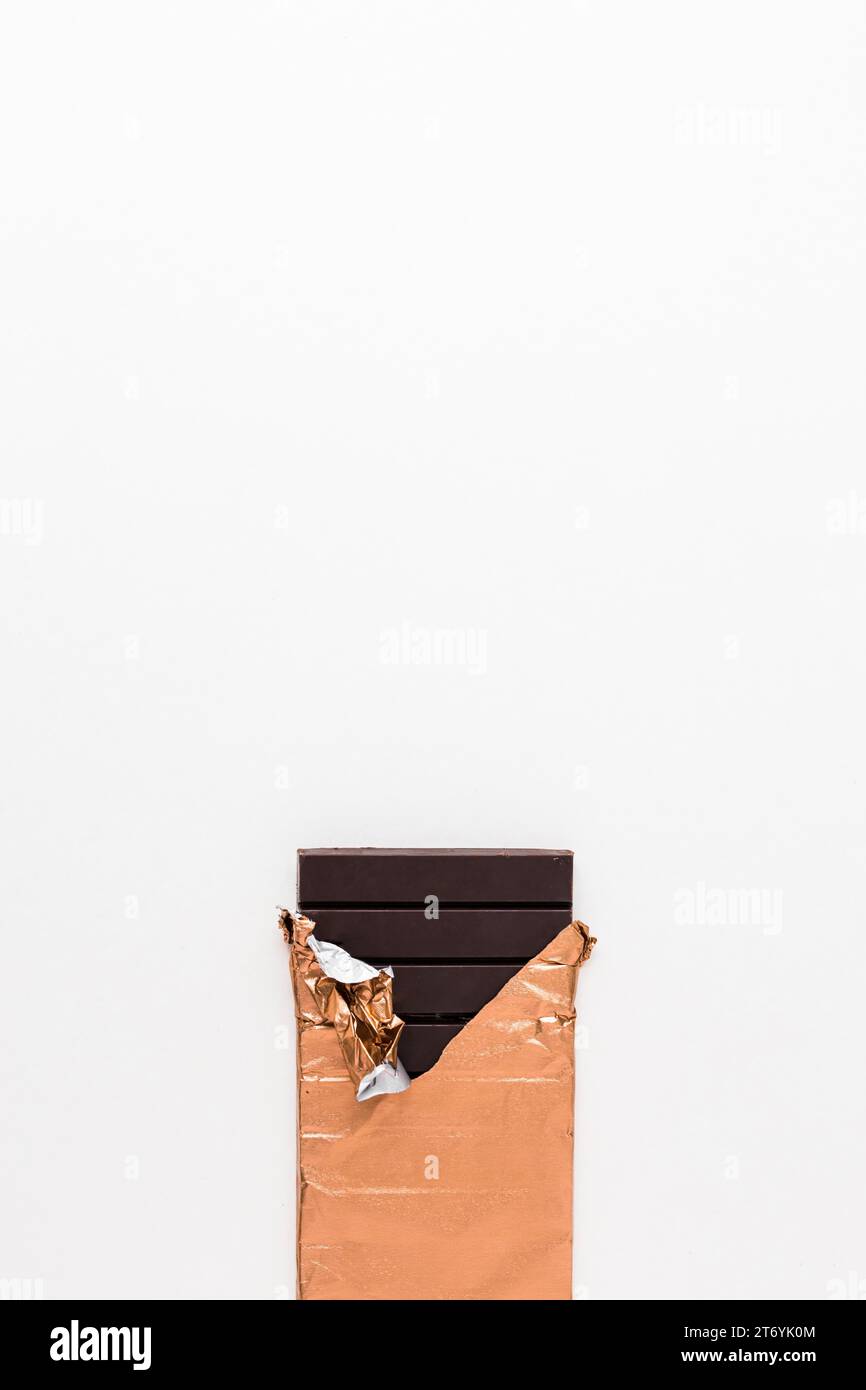 Dark chocolate bar golden wrapper white background Stock Photo - Alamy