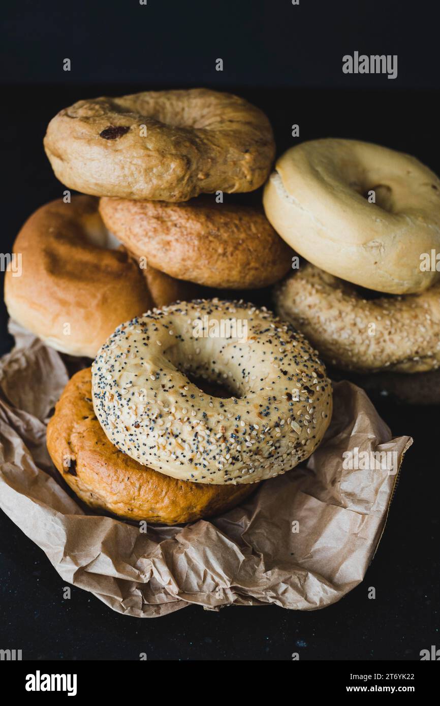 Different type bagels crumpled brown paper black background Stock Photo ...