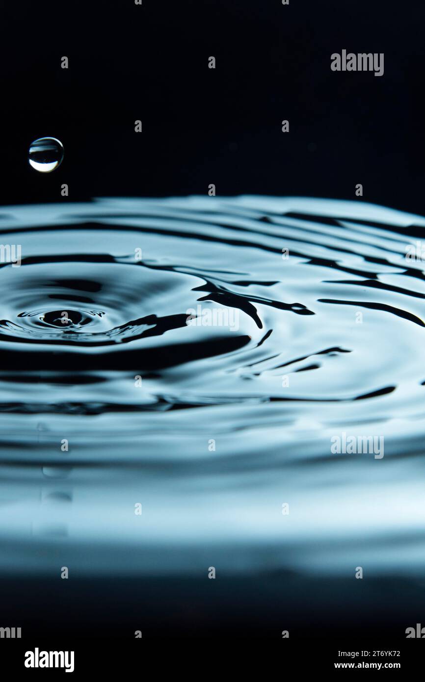Drop creating ripple effect liquid Stock Photo - Alamy