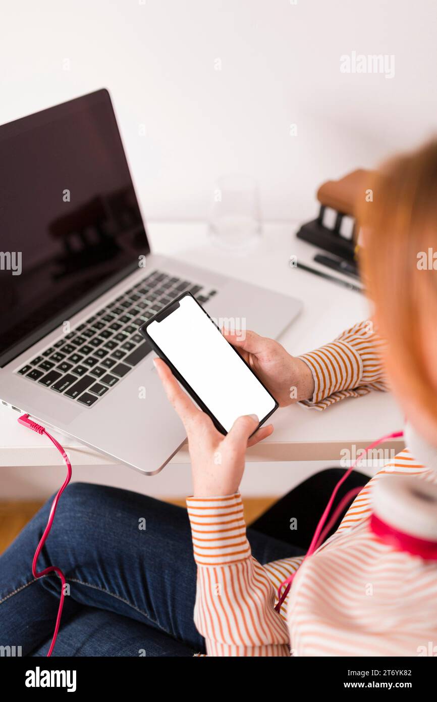 Female teacher using laptop smartphone during online class Stock Photo ...