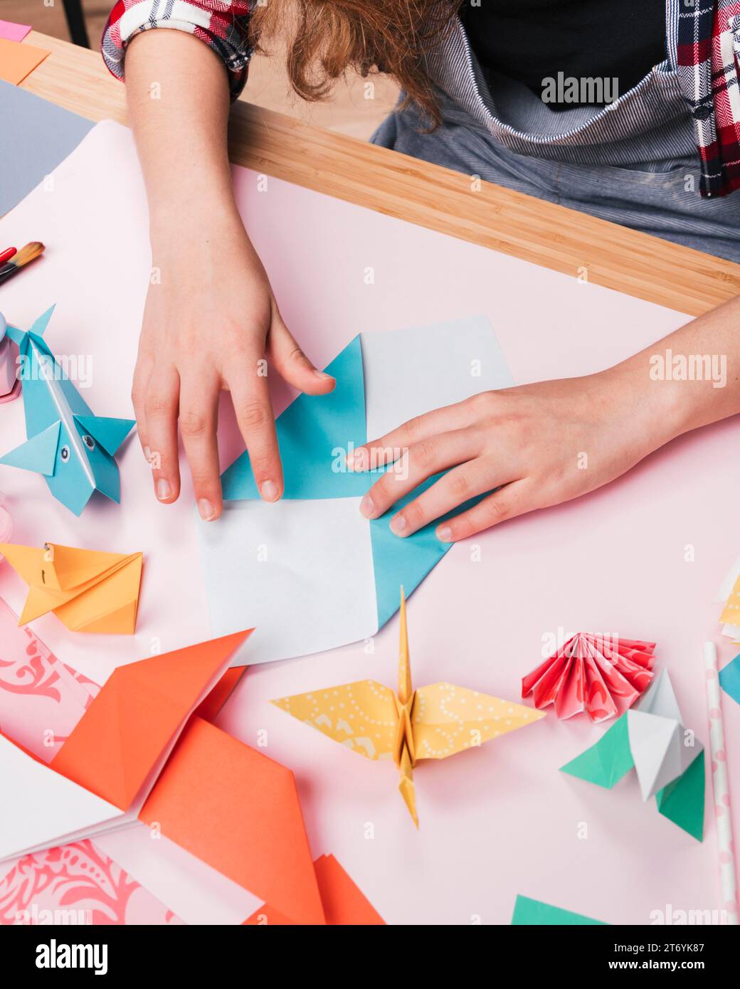 Female hand folding paper while making decorative origami art craft ...