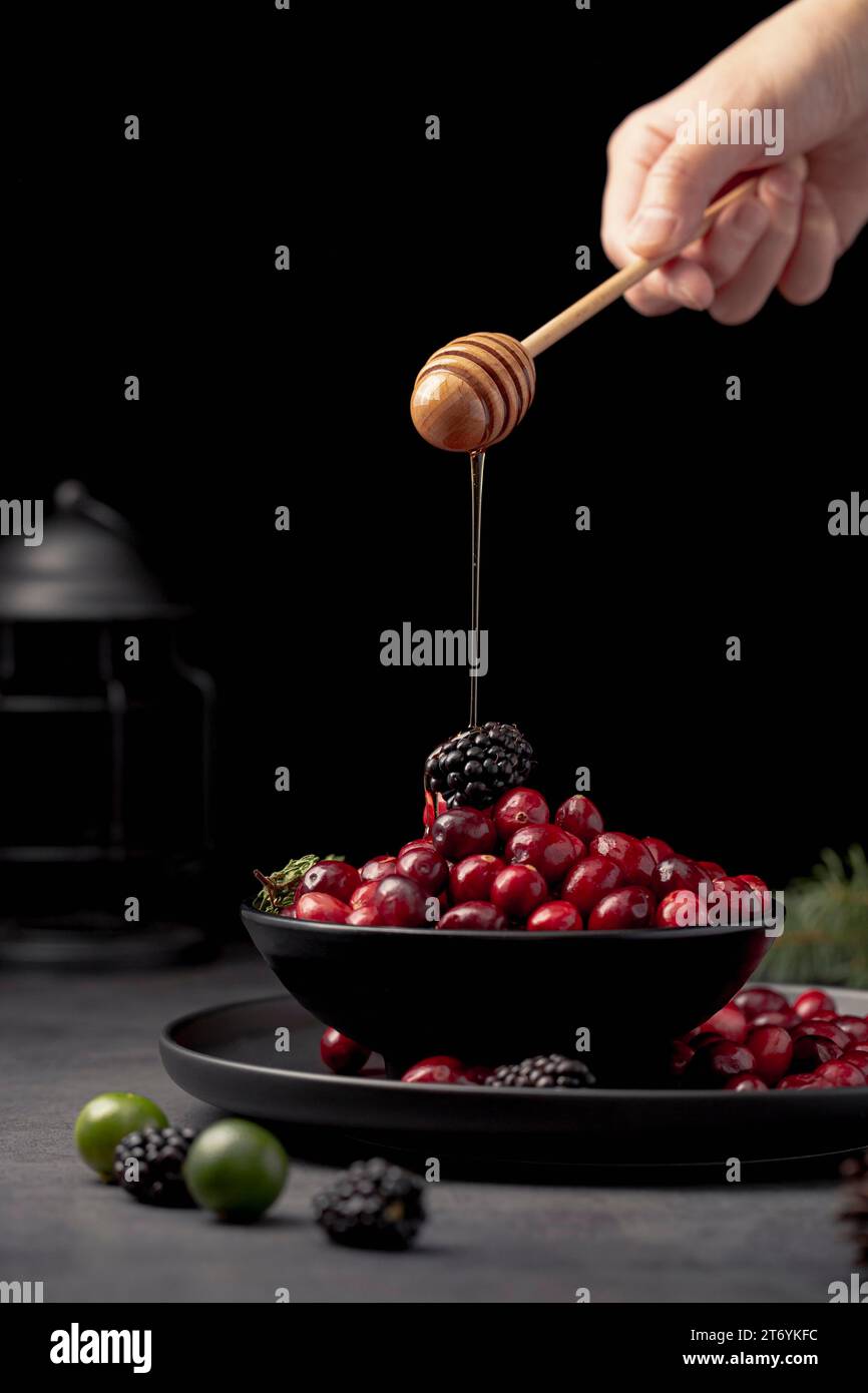 Front vie bowl with cranberries hand dripping honey them Stock Photo ...