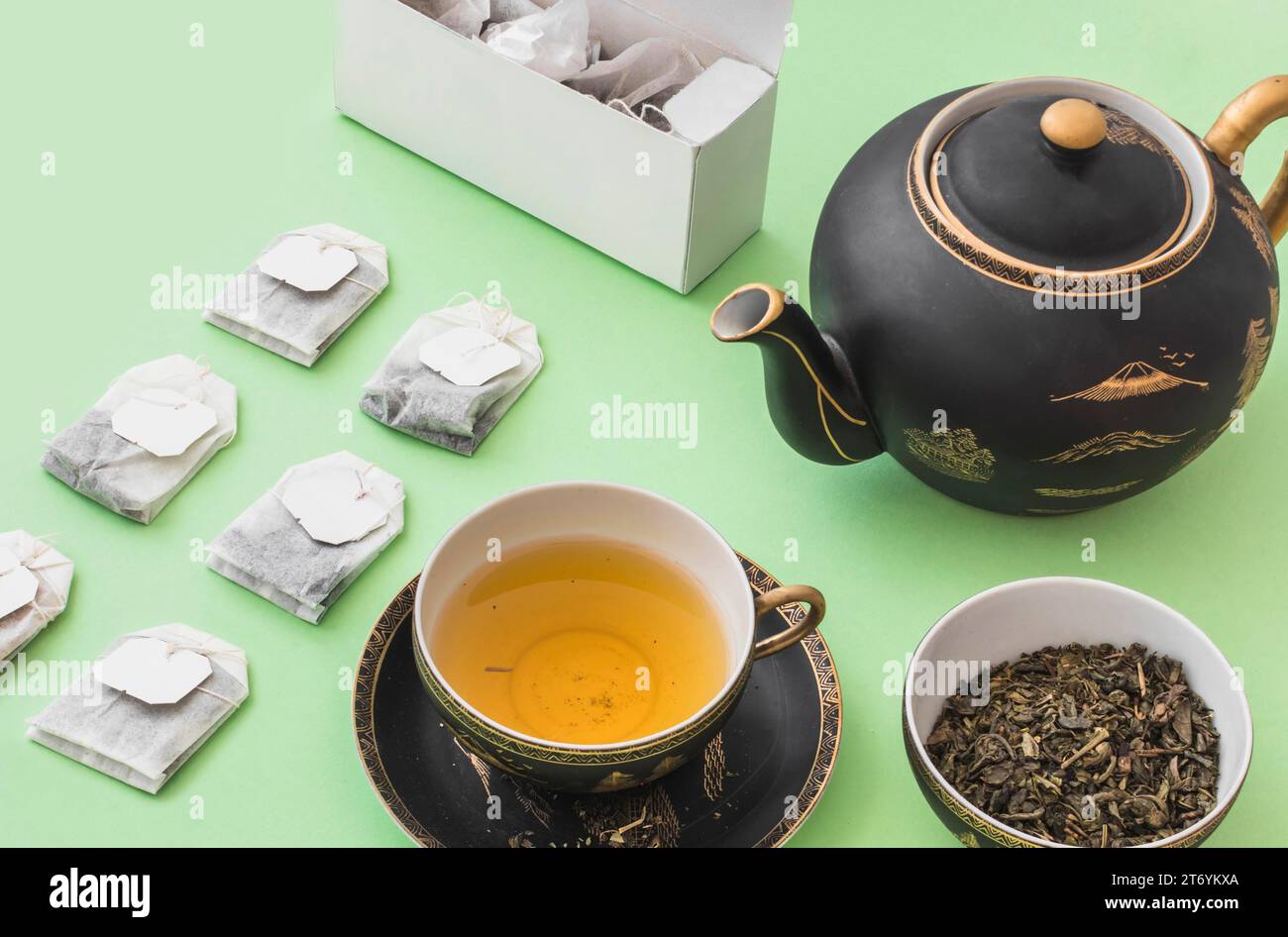 Herbal tea bags tea cup pale green paper background Stock Photo - Alamy