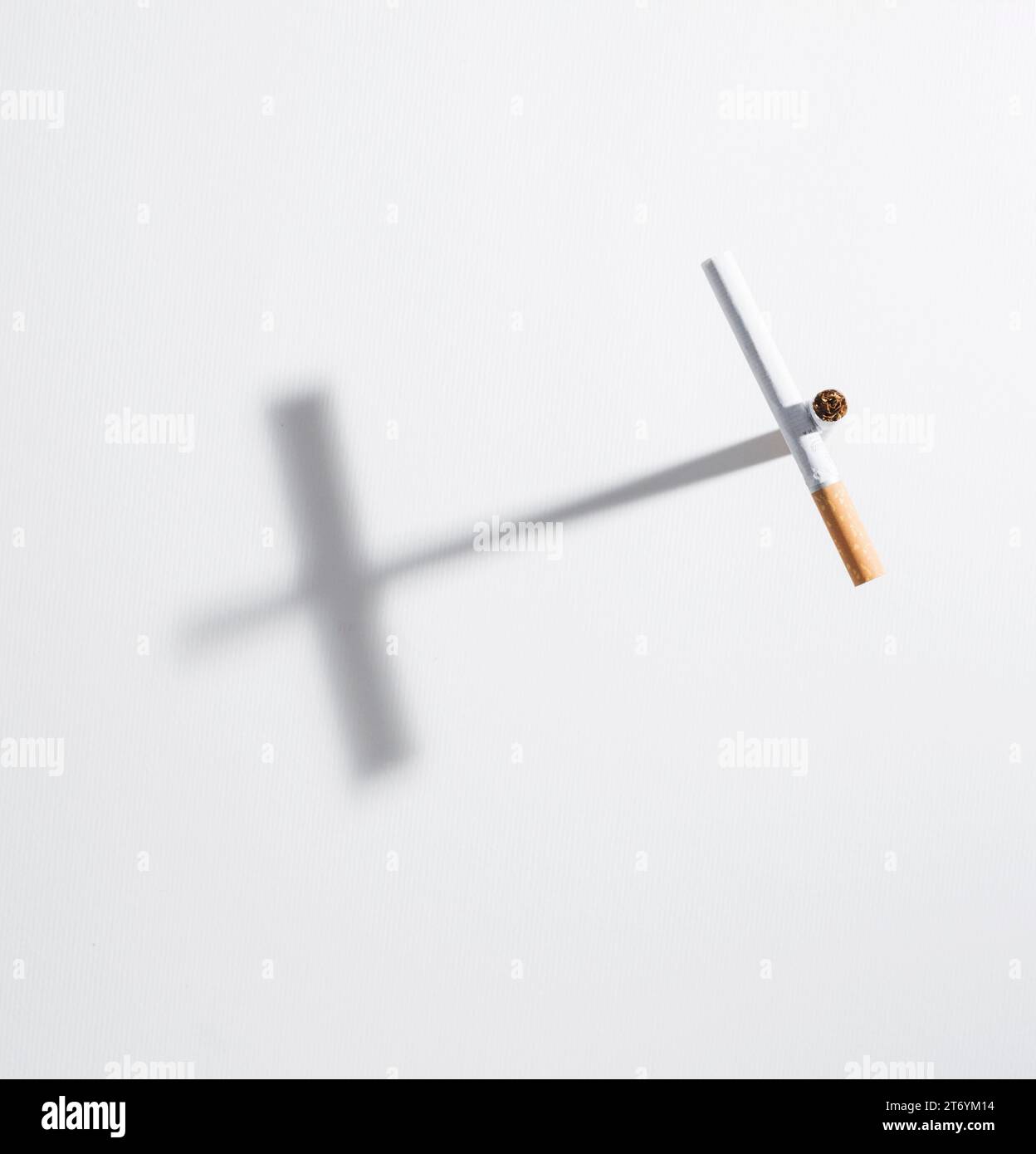 High angle view cross sign made from cigarette with it shadow isolated ...