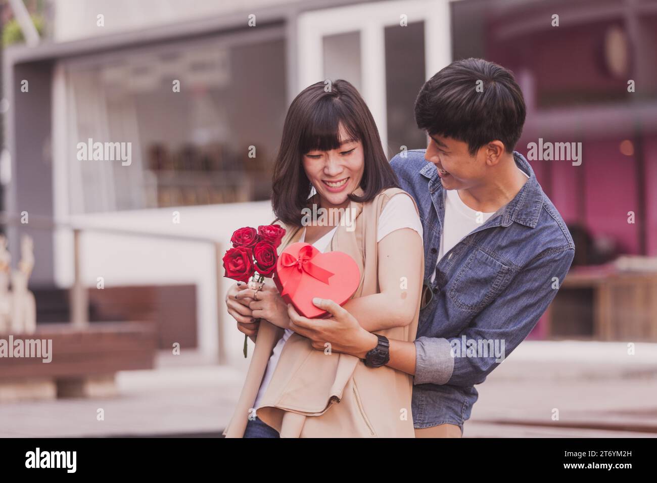 Man handing gift roses woman Stock Photo - Alamy