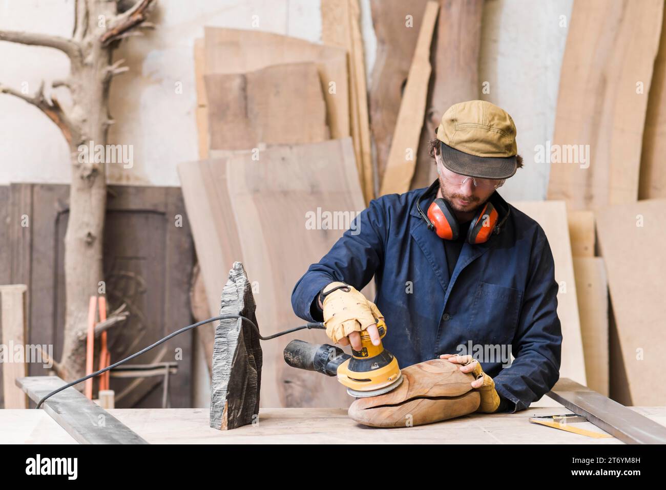 Man sanding wood with orbital sander workshop Stock Photo - Alamy