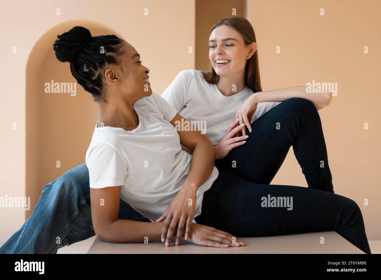 Medium shot women laughing together Stock Photo - Alamy