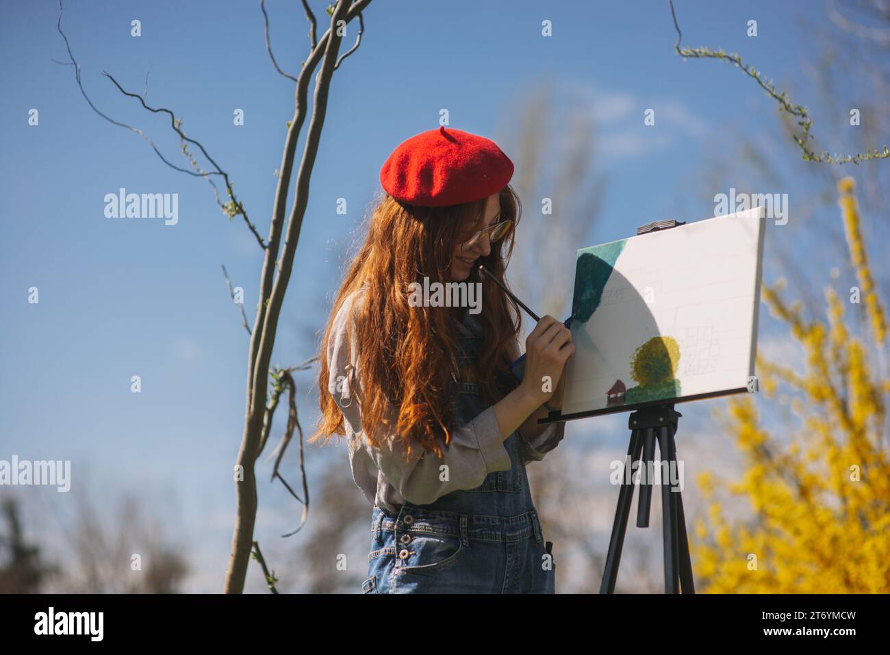 Woman wearing red hat is painting Stock Photo - Alamy