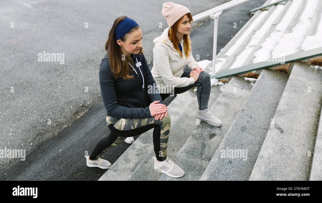 Overhead view young women stretching their legs staircase Stock Photo ...