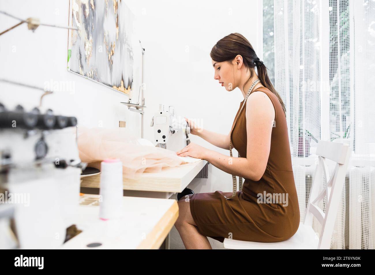 Side view young female designer working sewing machine Stock Photo - Alamy