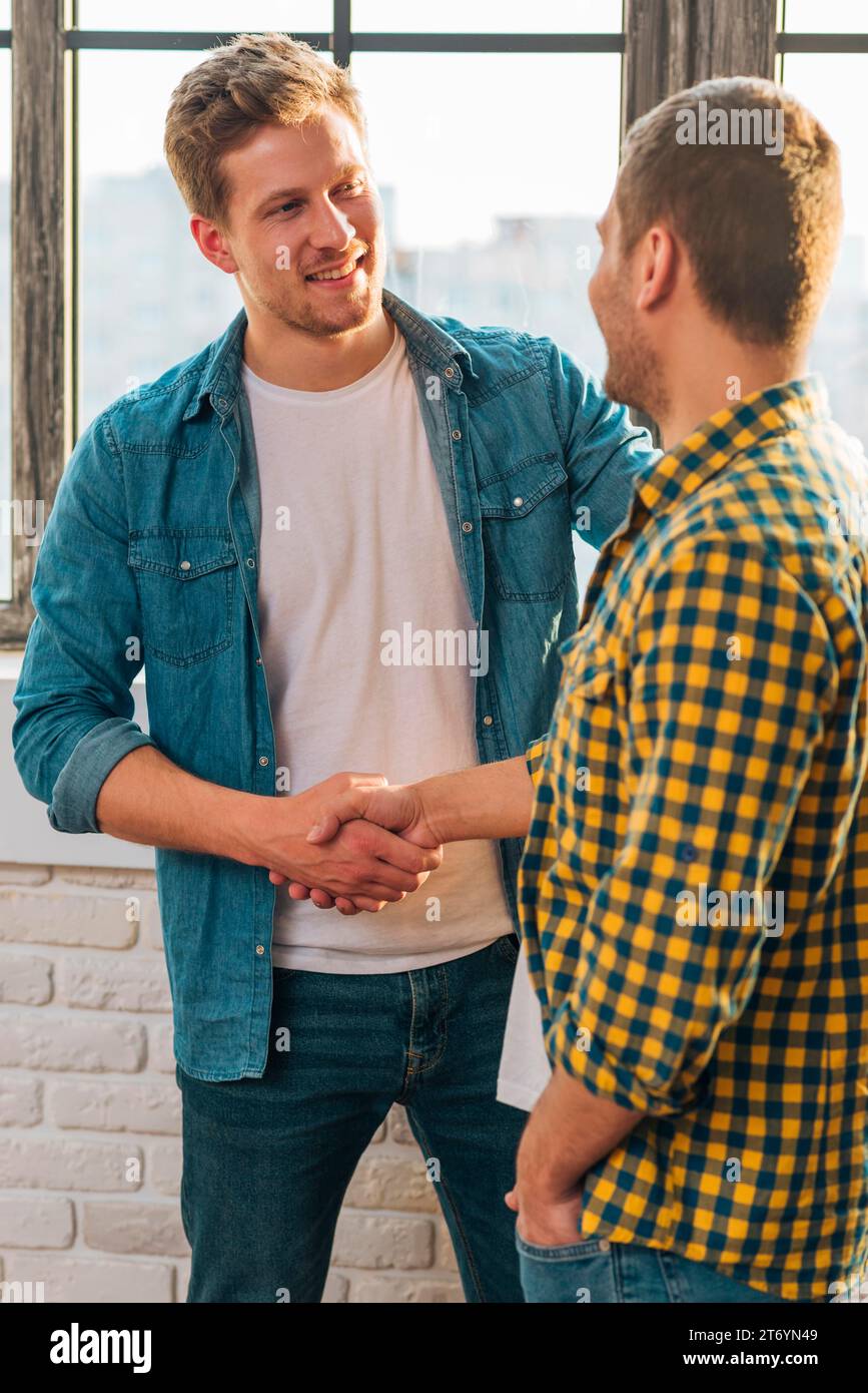 Smiling portrait young man shaking hands Stock Photo - Alamy