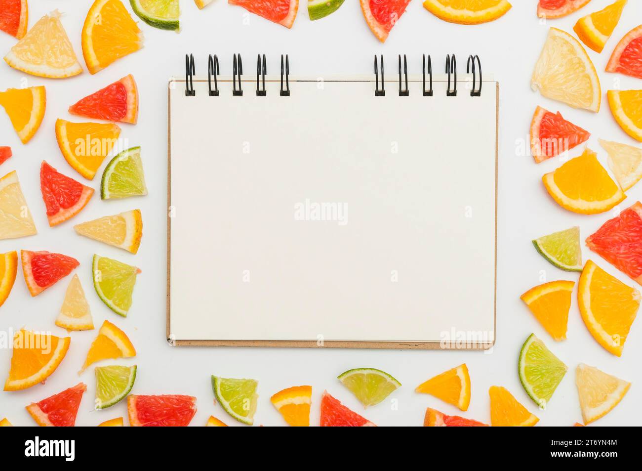 Spiral blank notepad surrounded with citrus triangular slices white ...