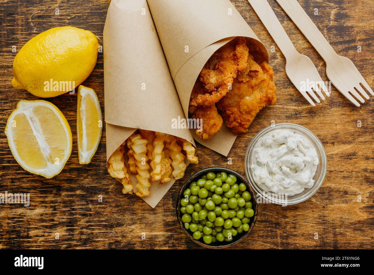 Top view fish chips paper wrap with peas cutlery Stock Photo - Alamy