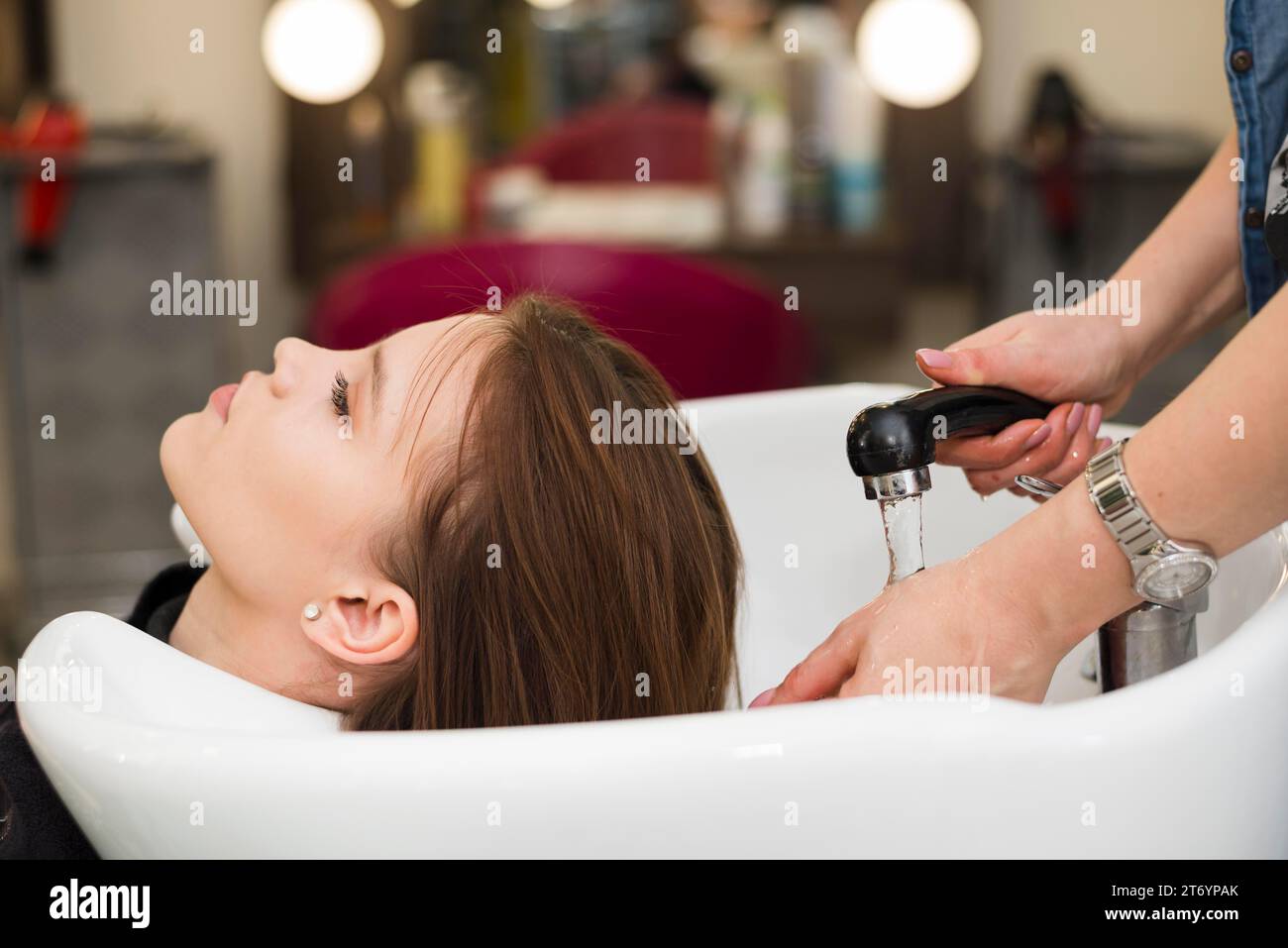 Brunette girl getting her hair washed Stock Photo - Alamy