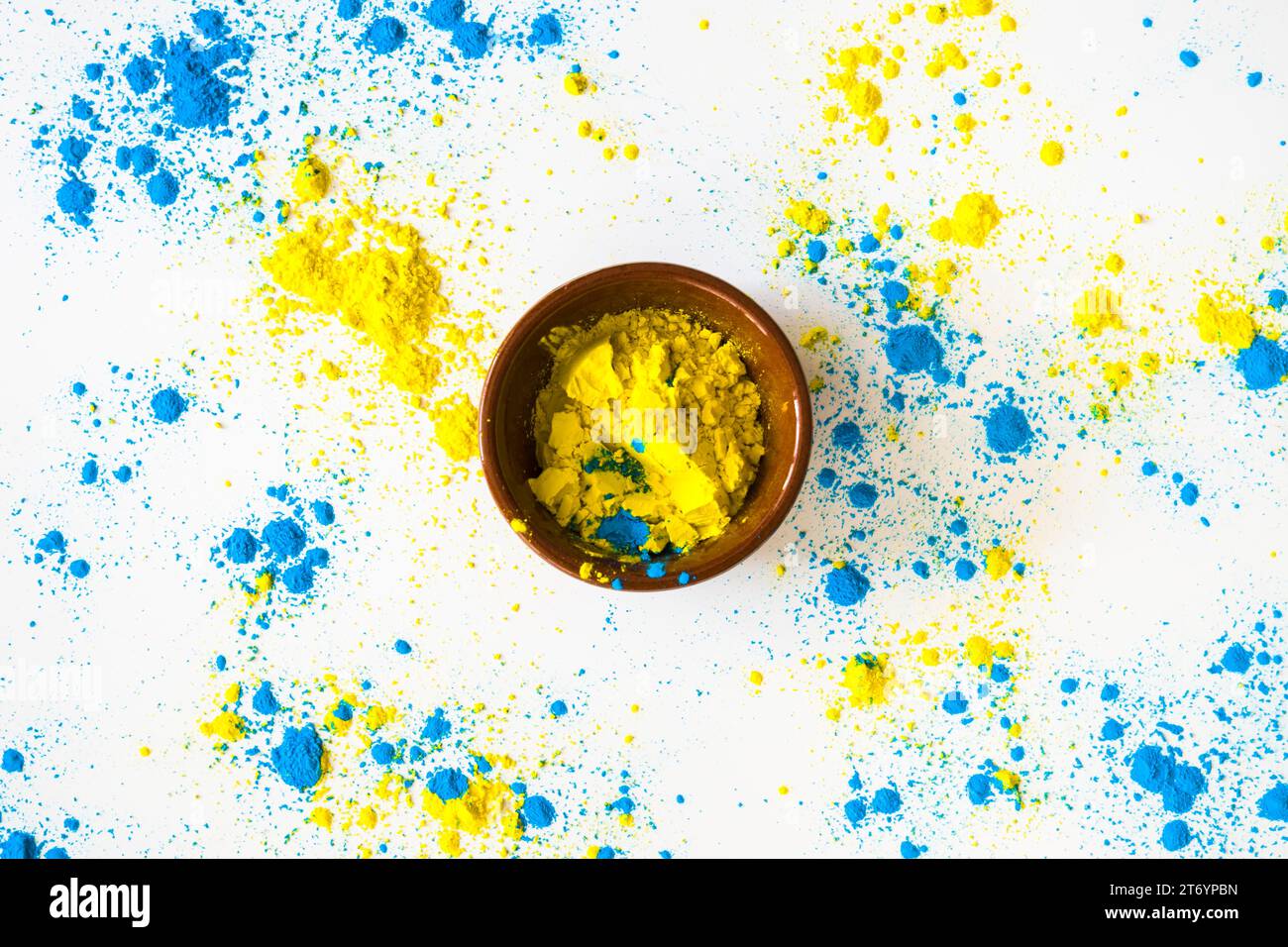 Blue yellow color powder around bowl white backdrop Stock Photo - Alamy