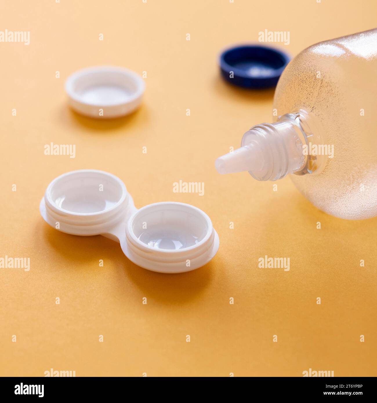 Bottle with lens solution lens box orange background Stock Photo - Alamy