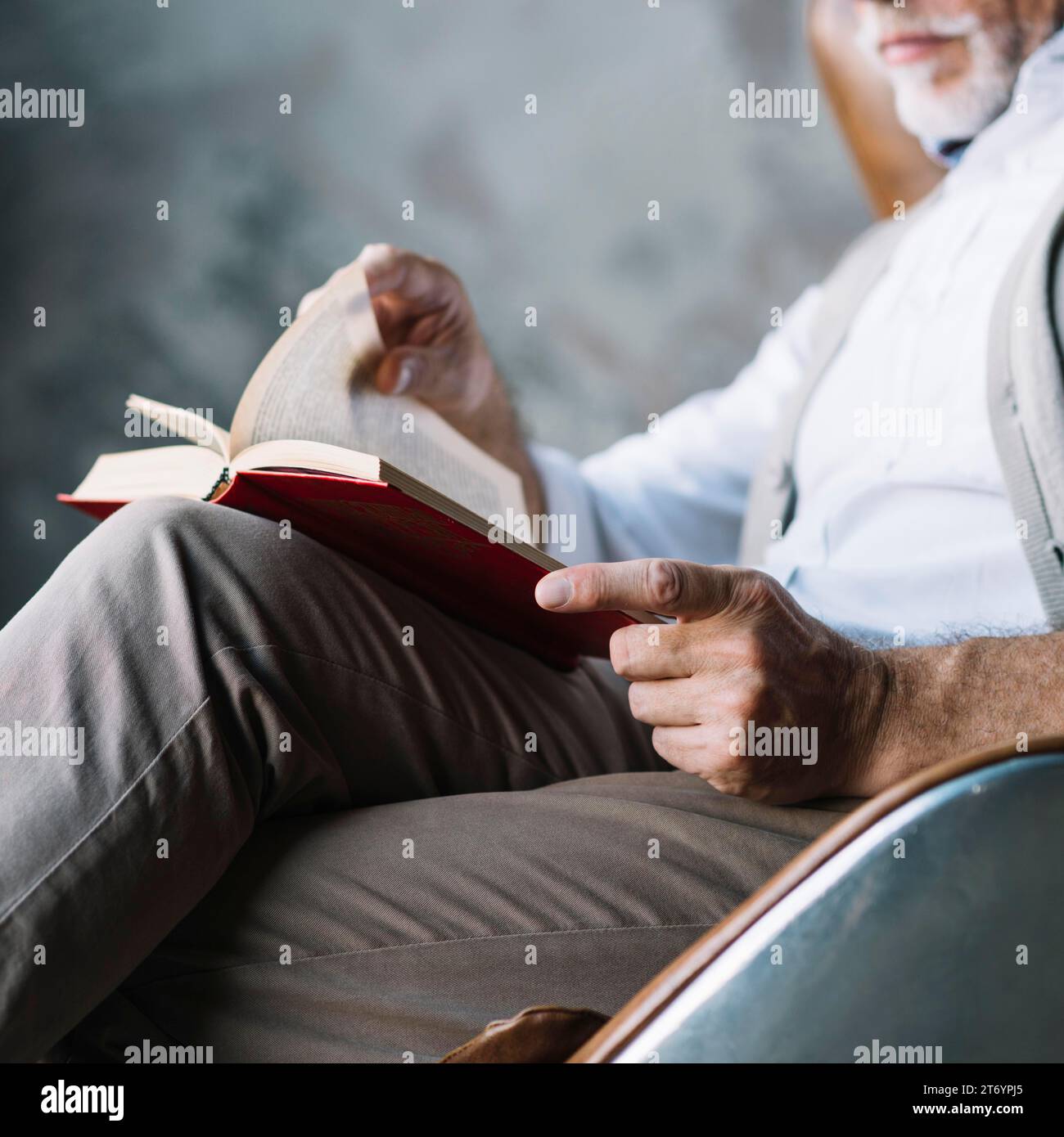 Close up man sitting chair reading book Stock Photo - Alamy