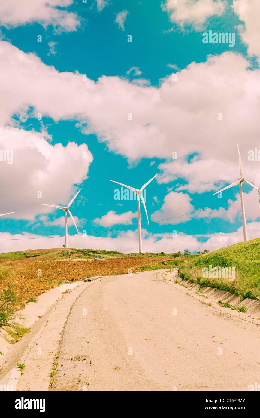 Clouds road wind turbines Stock Photo - Alamy