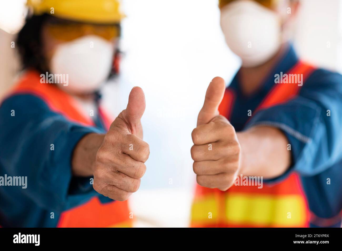 Colleagues with safety equipment showing ok sign Stock Photo - Alamy