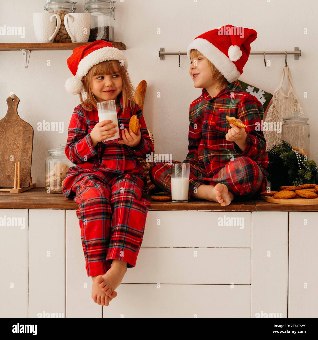 Cute children eating christmas cookies drinking milk Stock Photo - Alamy