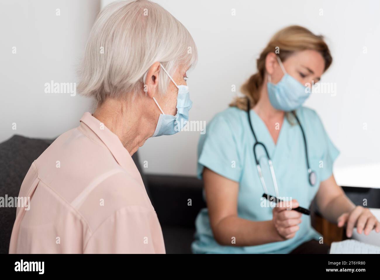 Female nurse elder woman nursing home during check up Stock Photo - Alamy