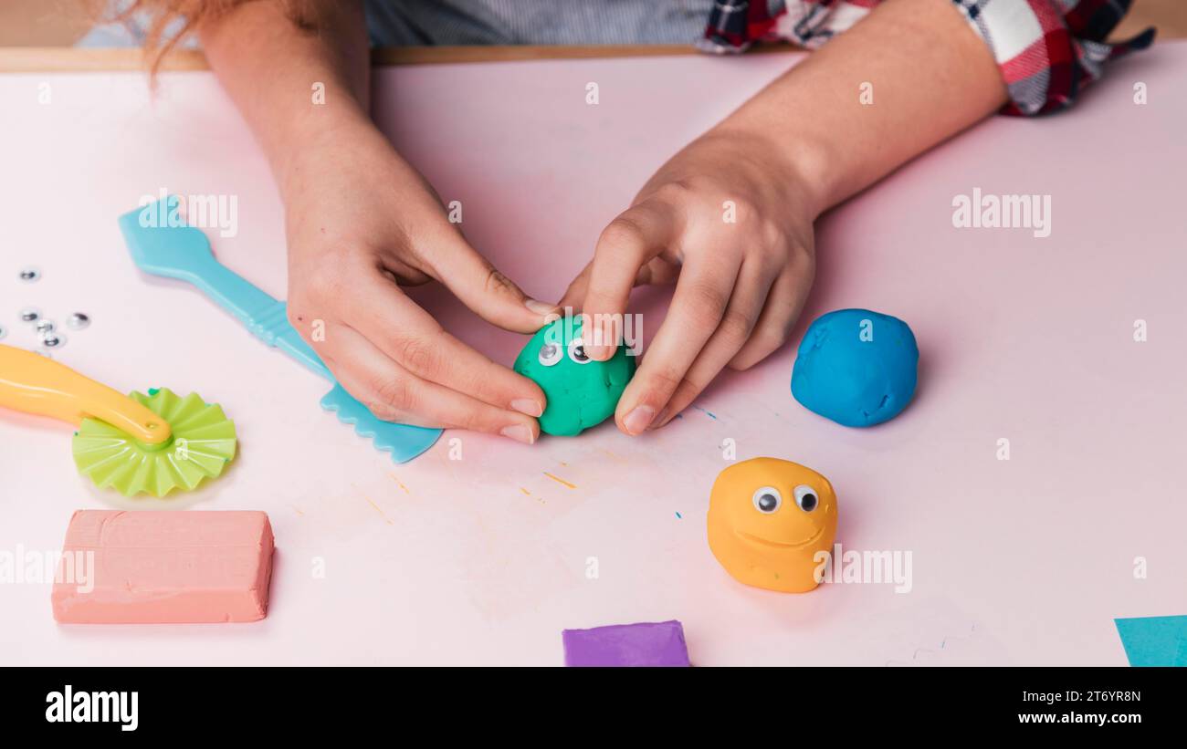 Female artist hand making cartoon faces using soft clay Stock Photo - Alamy