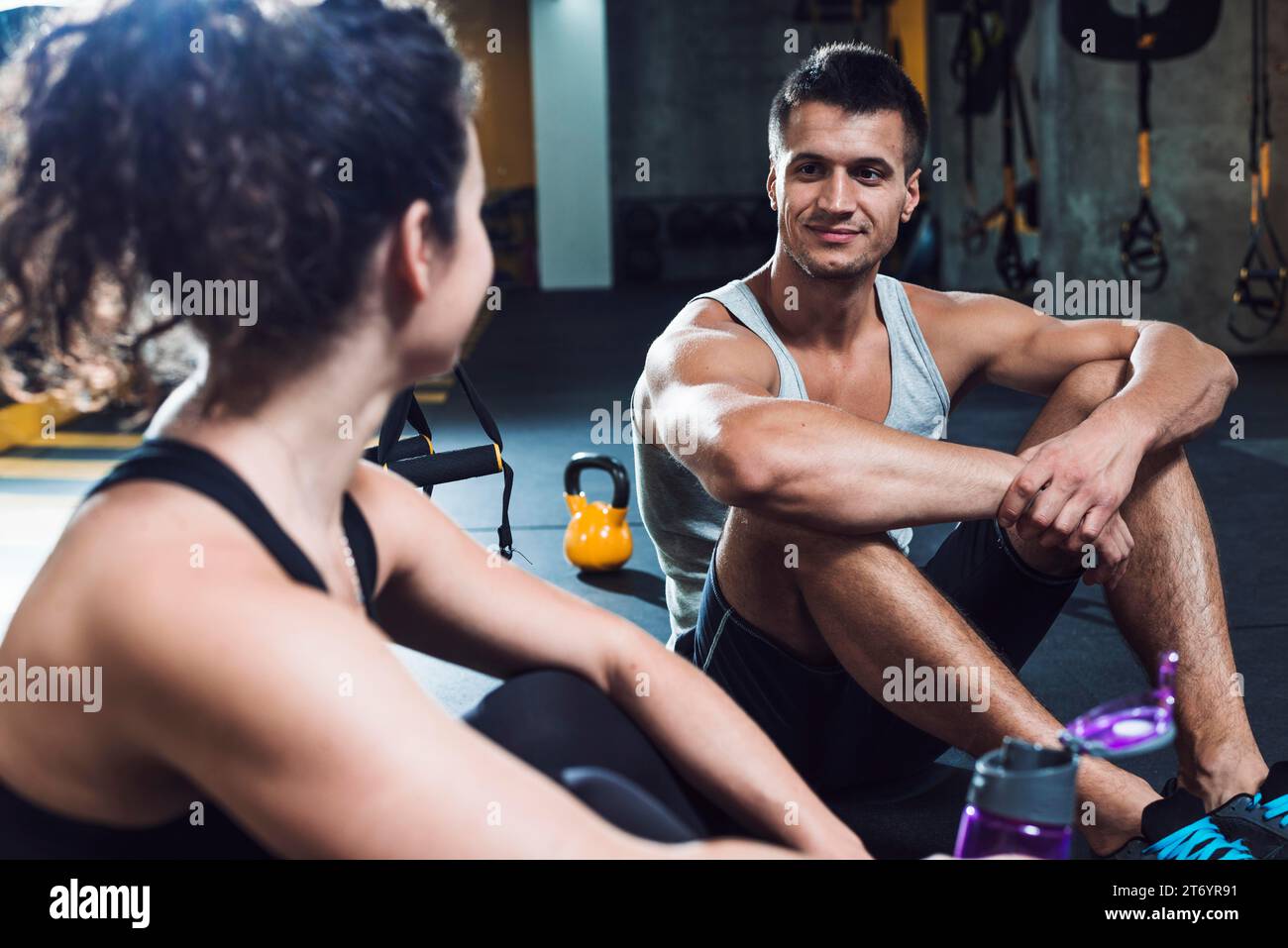 Fit couple sitting floor gym Stock Photo - Alamy
