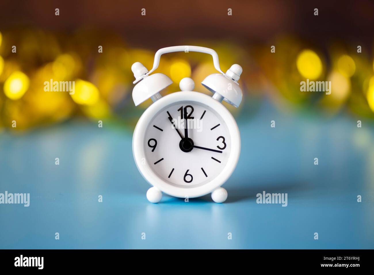 Front view white clock blurred golden background Stock Photo - Alamy