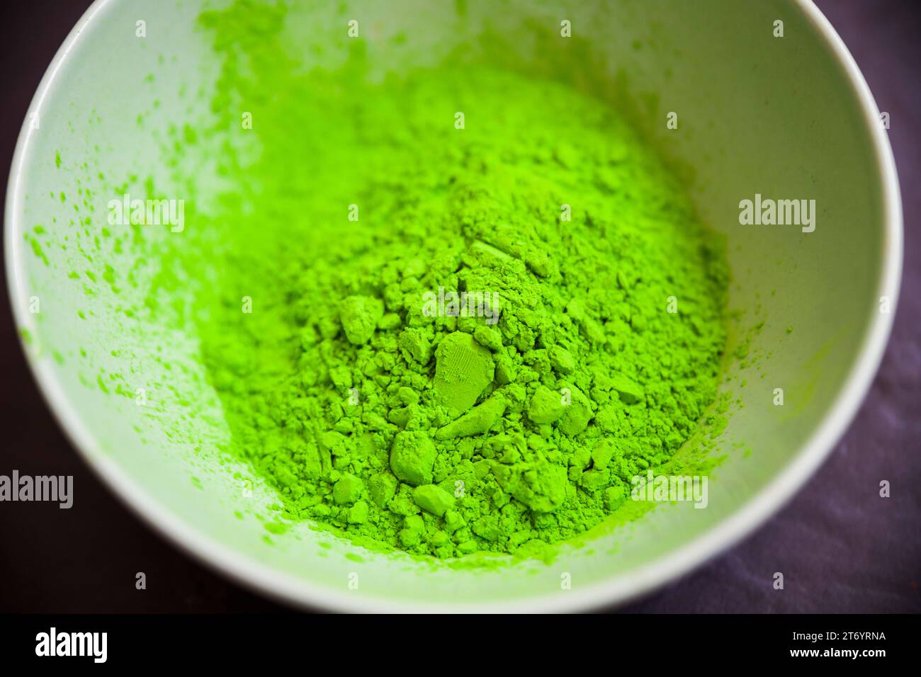 Green holi powder inside white bowl black backdrop Stock Photo - Alamy