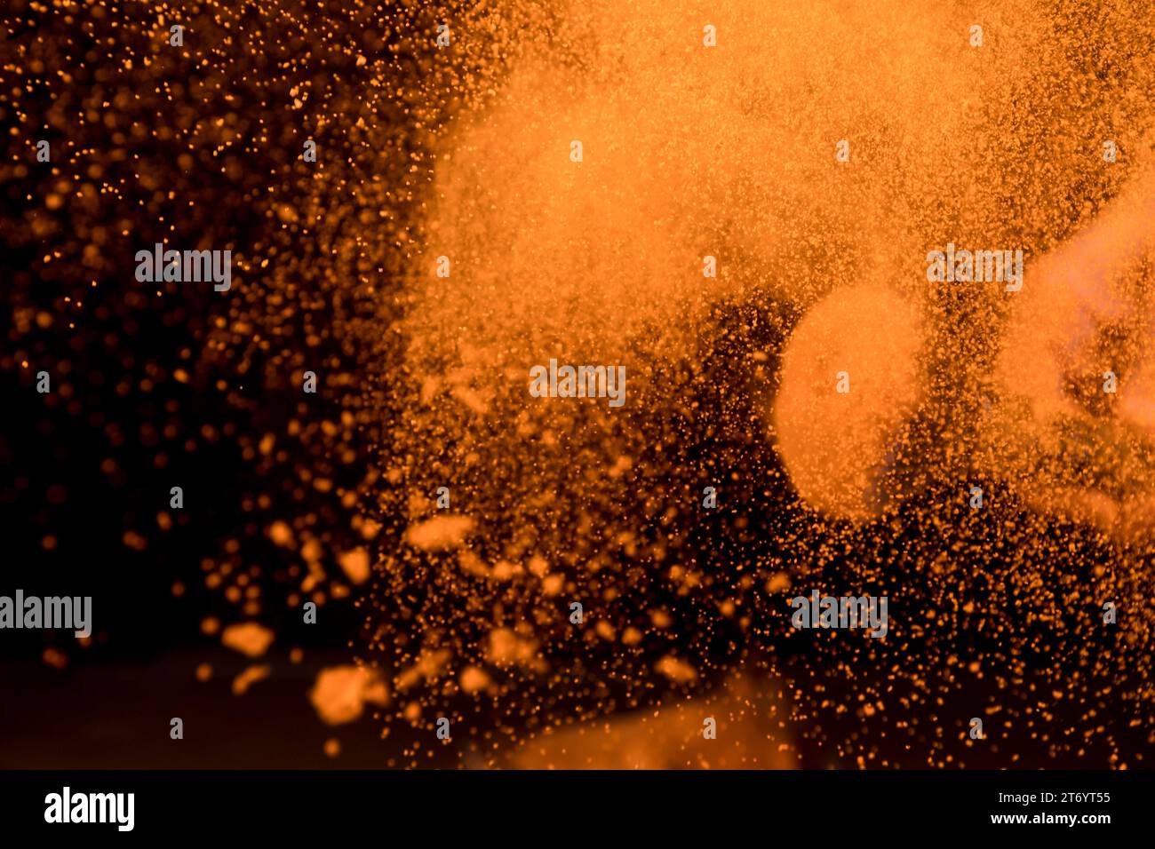 Large burst orange makeup powder dark background Stock Photo - Alamy