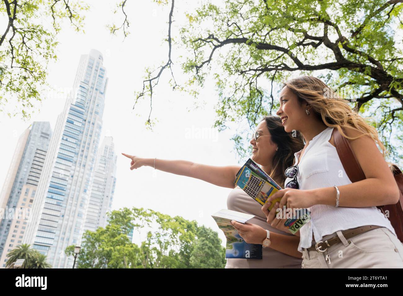 Low angle view female holding map hands looking her female pointing ...