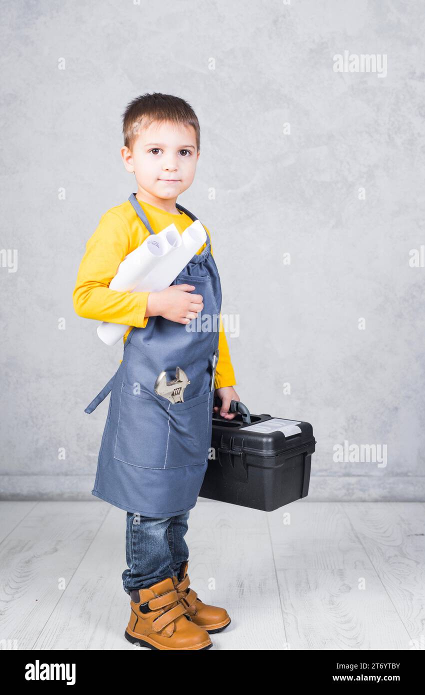 Little boy standing with tool box paper rolls Stock Photo - Alamy