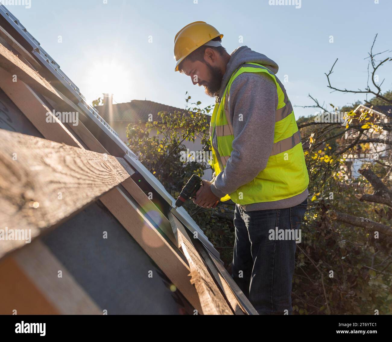 Man working roof with drill Stock Photo - Alamy