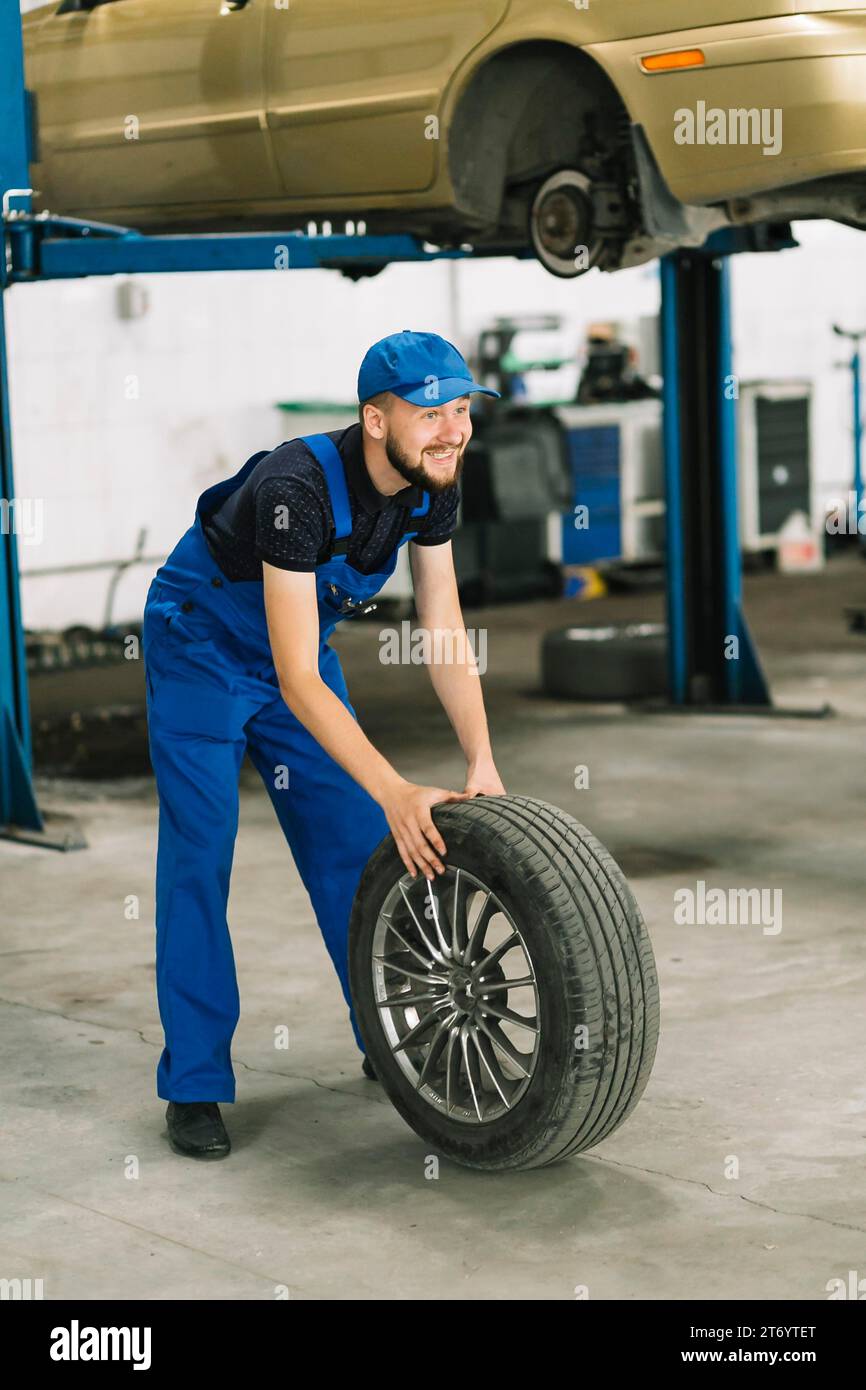 Mechanic rolling wheel car elevator Stock Photo - Alamy
